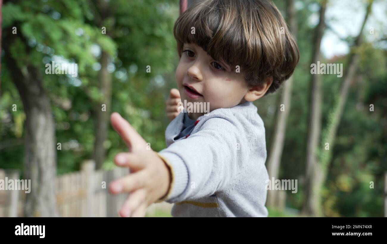 Little boy reaching for rope at playground structure. Active child ...