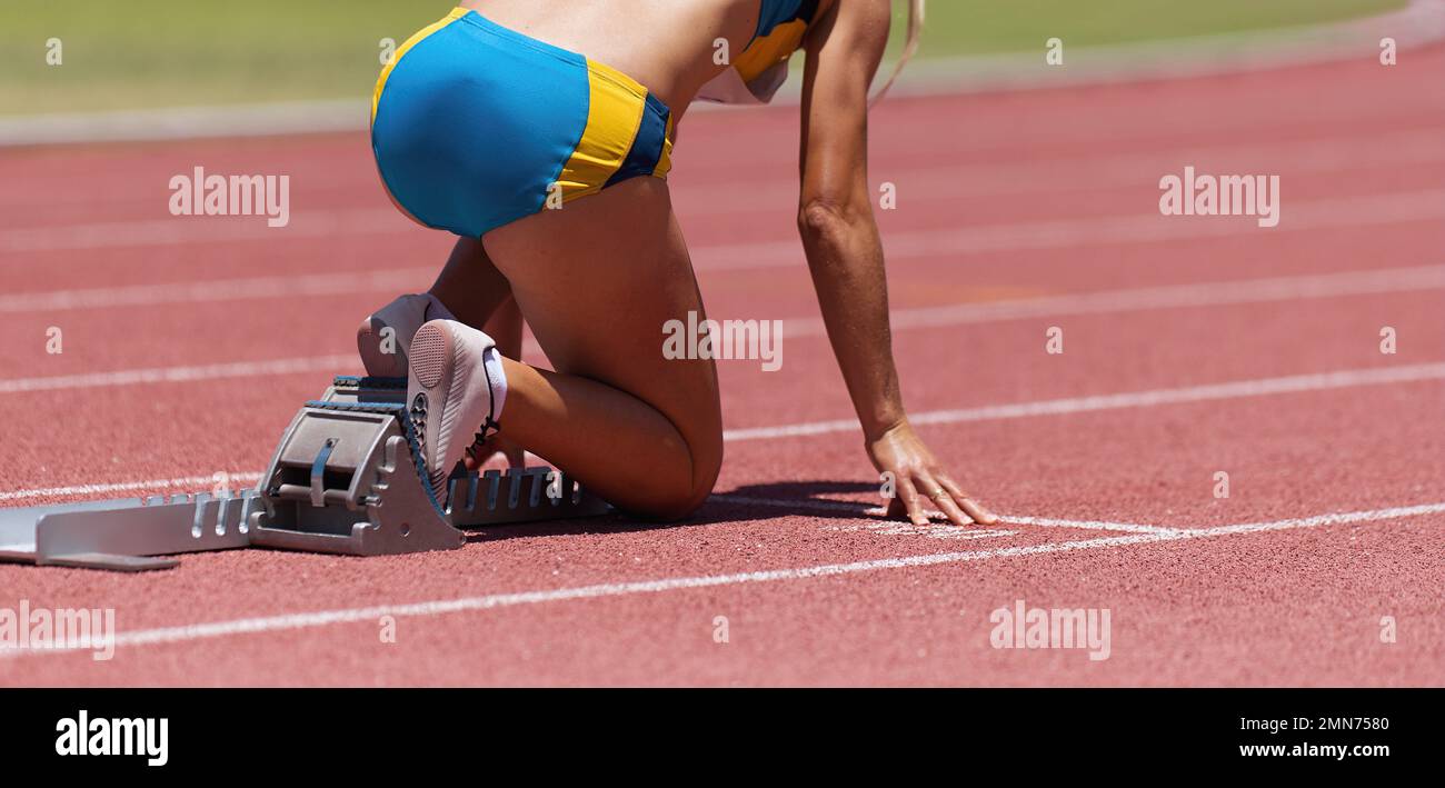 Woman athlete at start position ready to start and race, ready to run ...