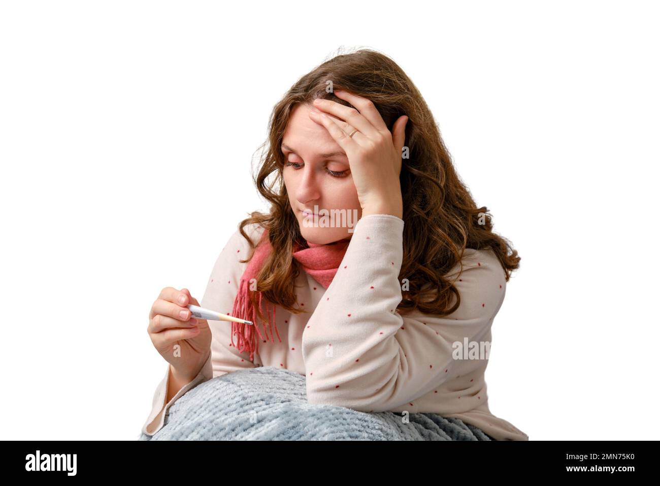 A sick woman looks at a thermometer in her hand in her hand, fever and ...