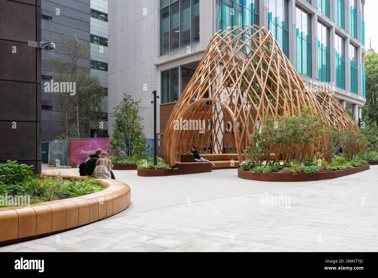 People sitting in the landscaping looking towards the pavilions ...