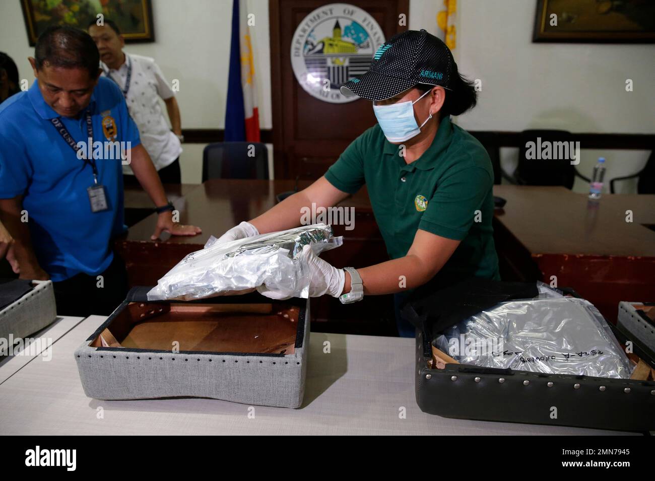 A member of the Philippine Drug Enforcement Agency returns packs of ...