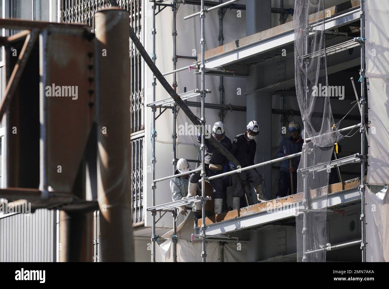 In this March 22, 2018 photo, workers adjust a hose at a construction ...
