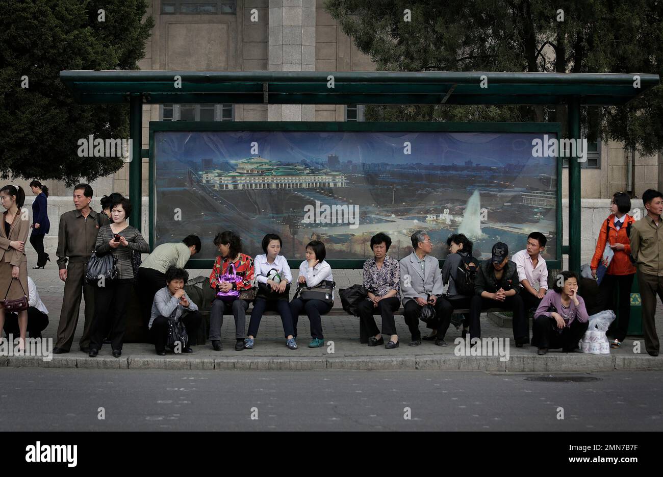FILE - Commuters wait for a trolley bus to arrive in downtown Pyongyang ...