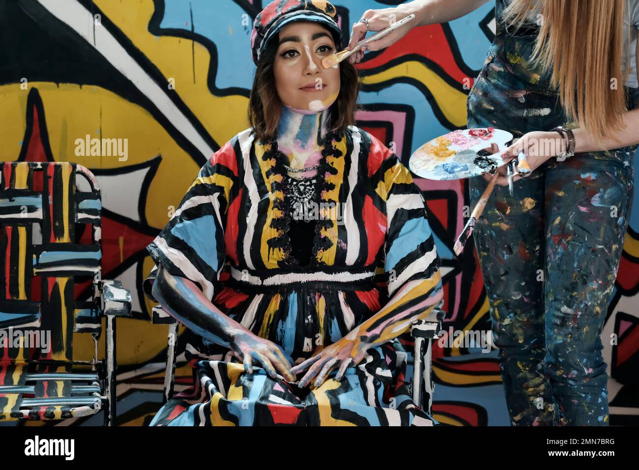 Artist Alexa Meade, right, paints the face of model Justine Jaime ...