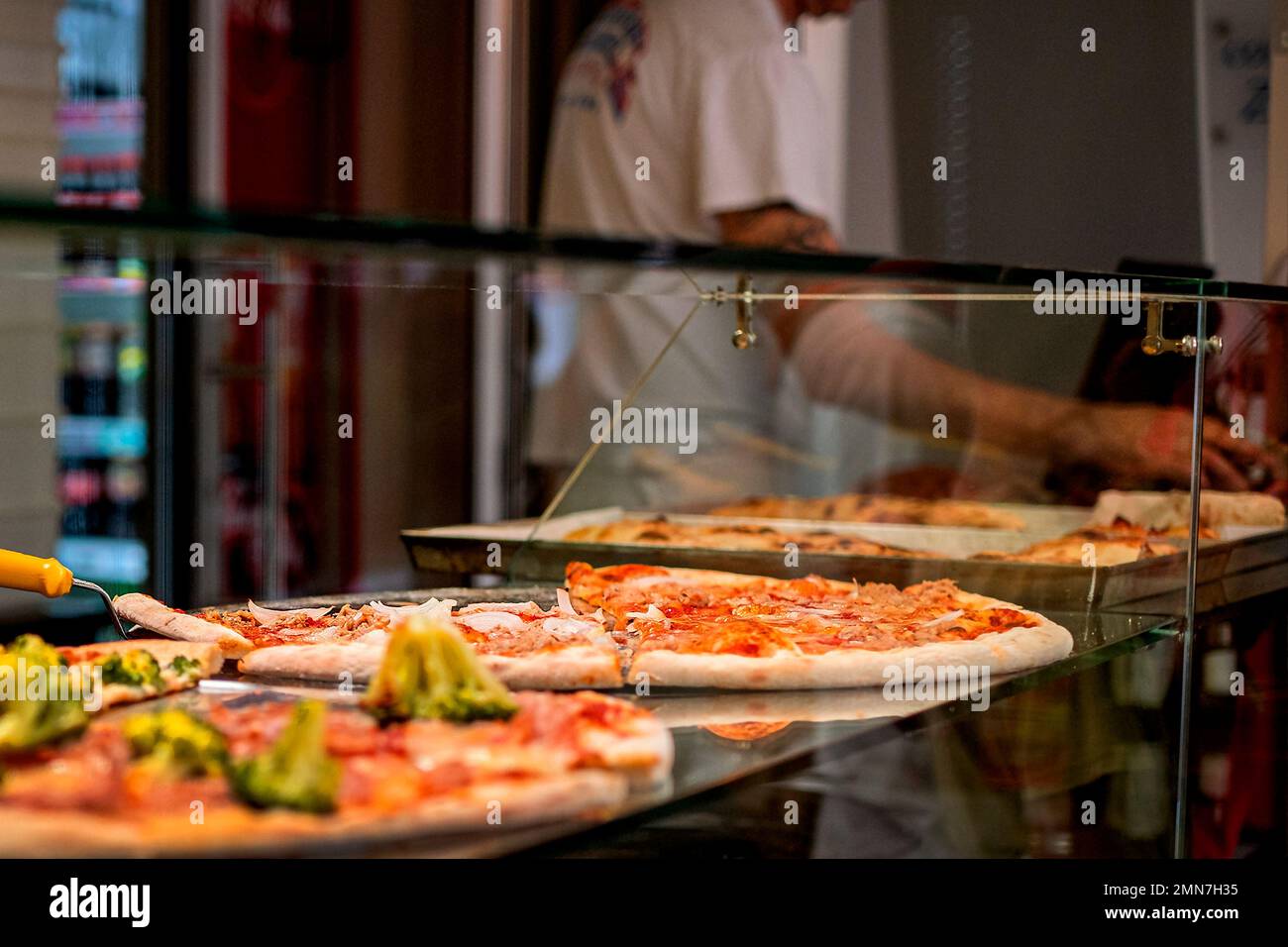 Large pizza cut into slices on the counter, italian street style Stock ...