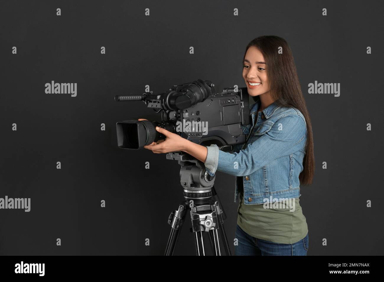 Operator with professional video camera on black background Stock Photo ...