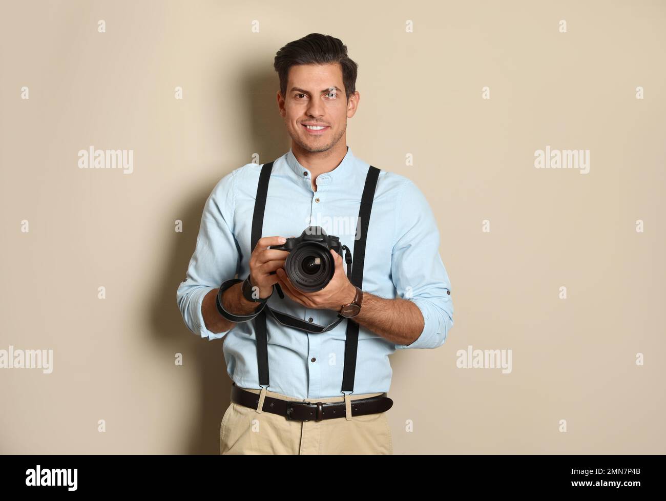 Professional photographer working on beige background in studio Stock ...