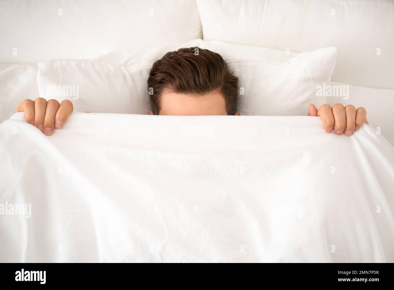Man under blanket in bed at home, top view. Lazy morning Stock Photo ...