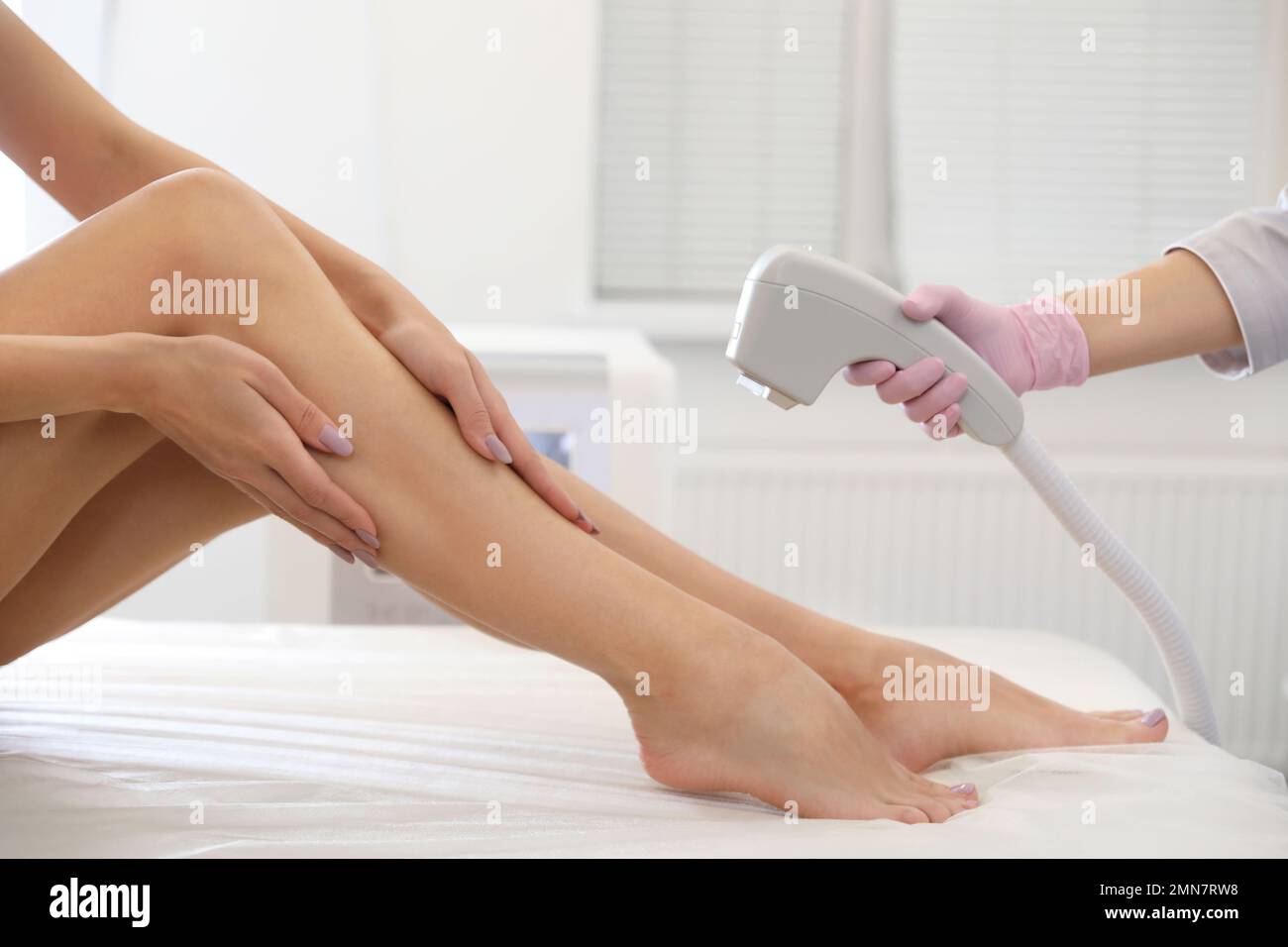 Young woman undergoing laser epilation procedure in beauty salon ...