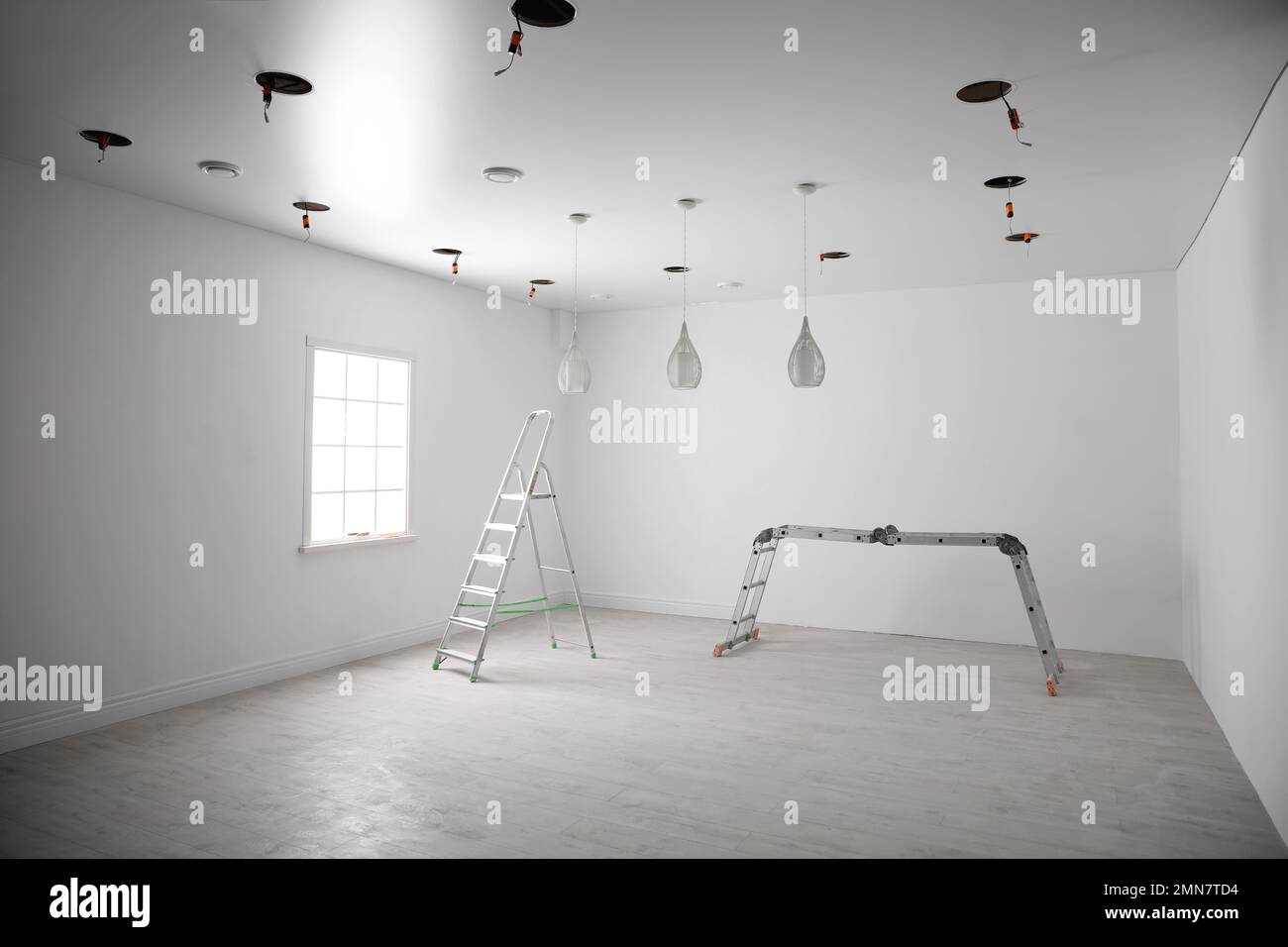 Empty room with stretch ceiling and ladders Stock Photo - Alamy