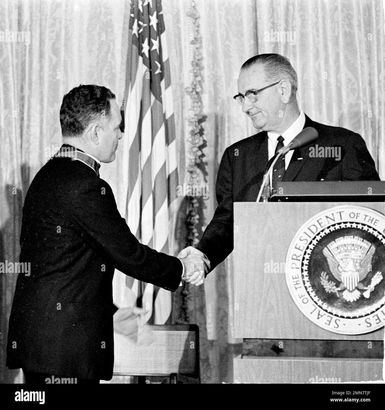 President Lyndon B. Johnson shakes hands with the Rev. Theodore M ...