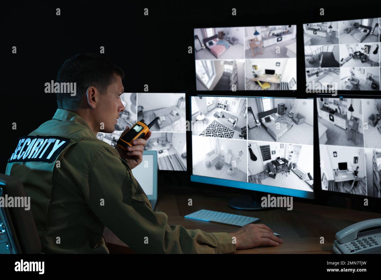 Security guard with portable transmitter monitoring modern CCTV cameras ...