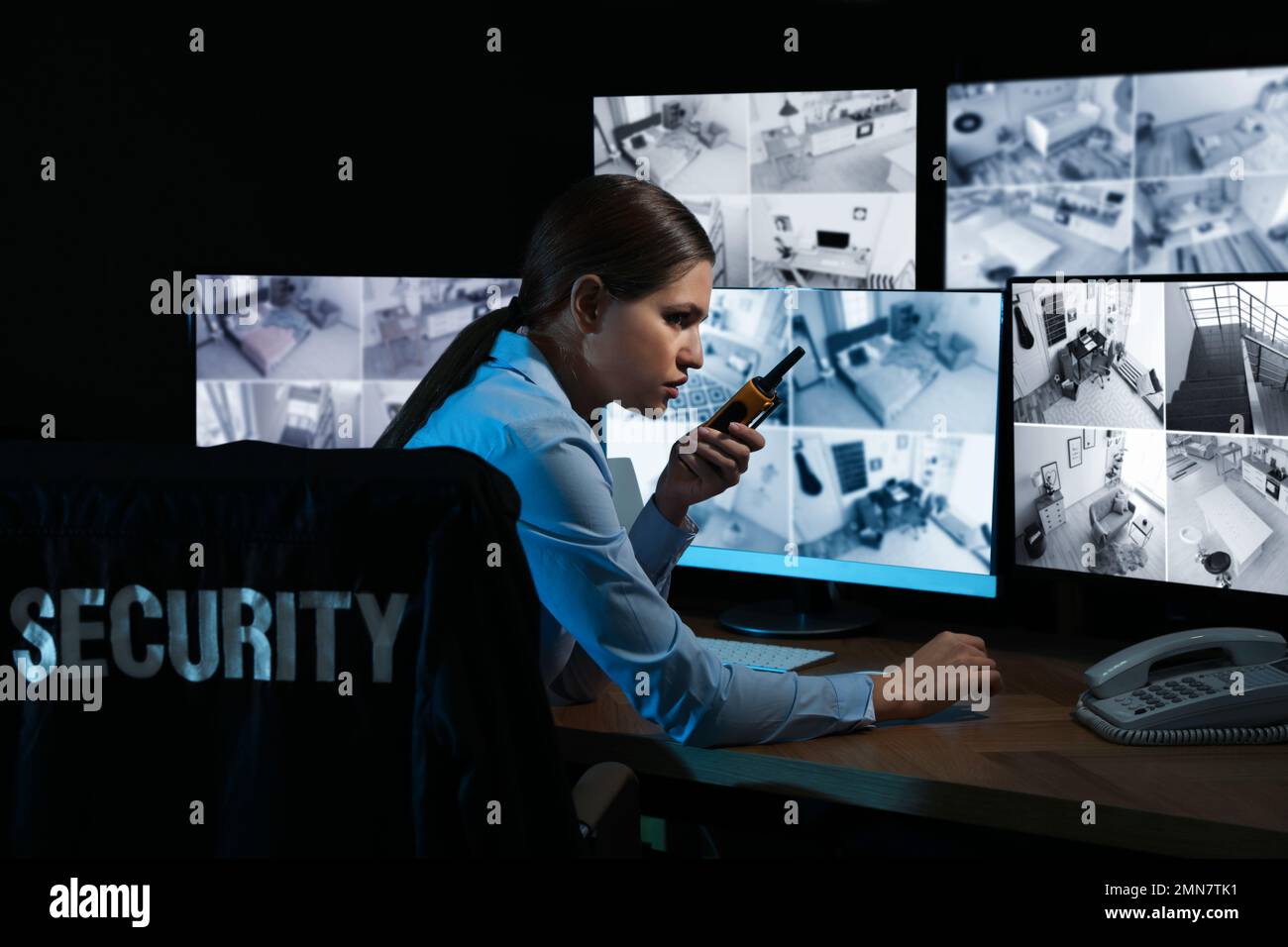 Security guard with portable transmitter monitoring modern CCTV cameras ...