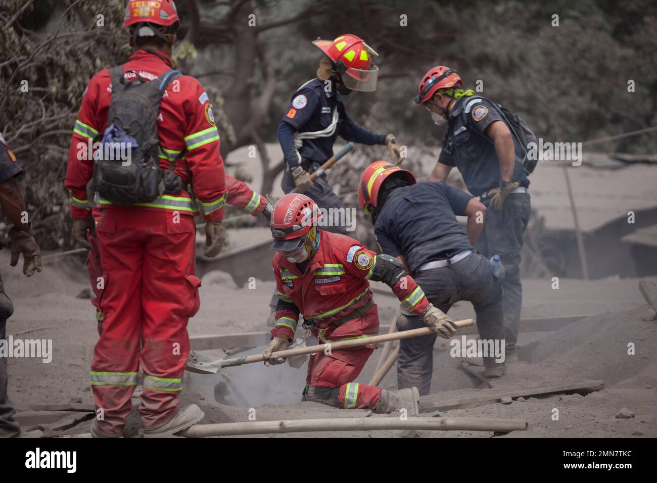 Firefighters work in the disaster zone near the Volcan de Fuego, or ...