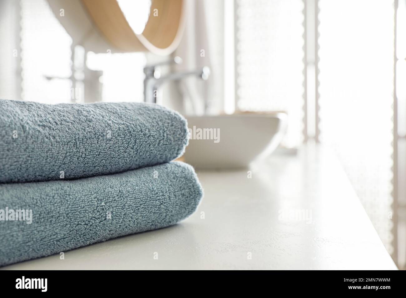 Stack of clean towels on countertop in bathroom. Space for text Stock ...