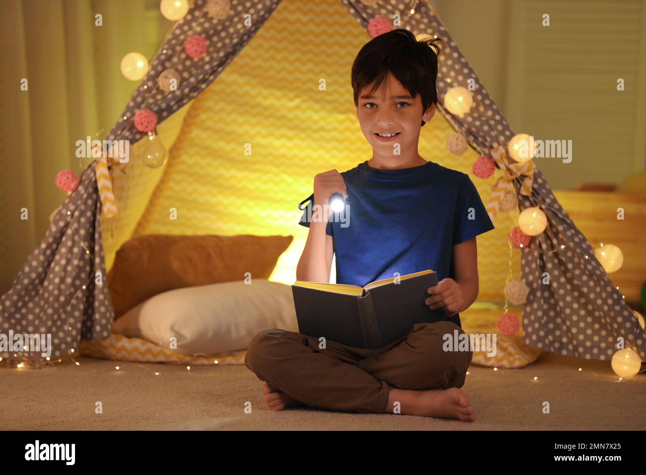 Preteen boy with flashlight reading book at home Stock Photo - Alamy