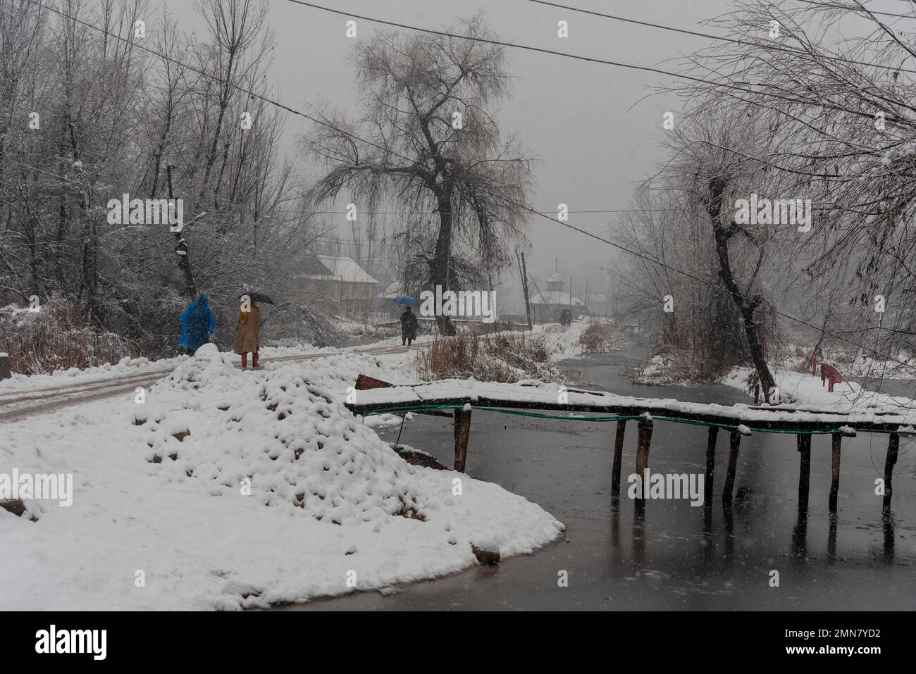 Srinagar, India. 30th Jan, 2023. People walk on snow covered road ...