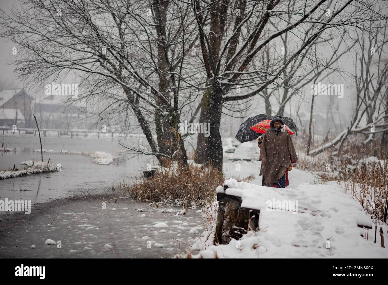 Srinagar, India. 30th Jan, 2023. People walk on snow covered road ...