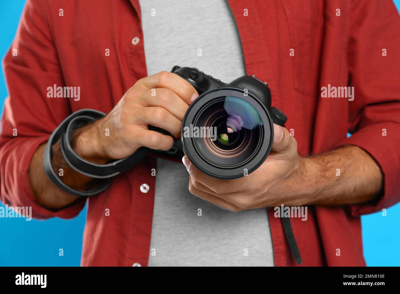 Professional photographer working on light blue background in studio ...