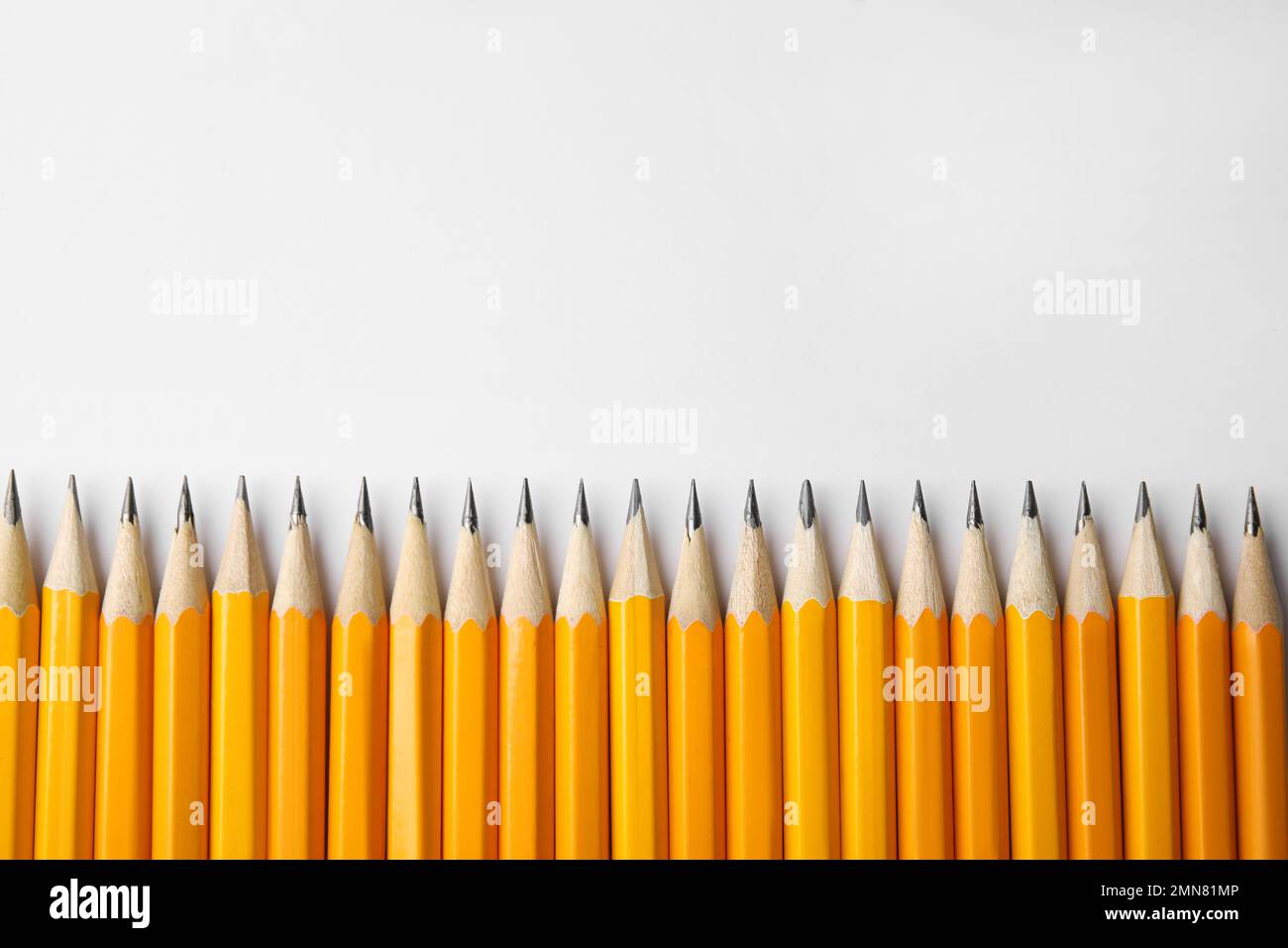 Many graphite pencils on white background, top view. Space for text ...