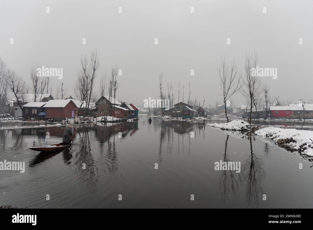 Srinagar, India. 30th Jan, 2023. Boatmen row their boats on Dal Lake ...