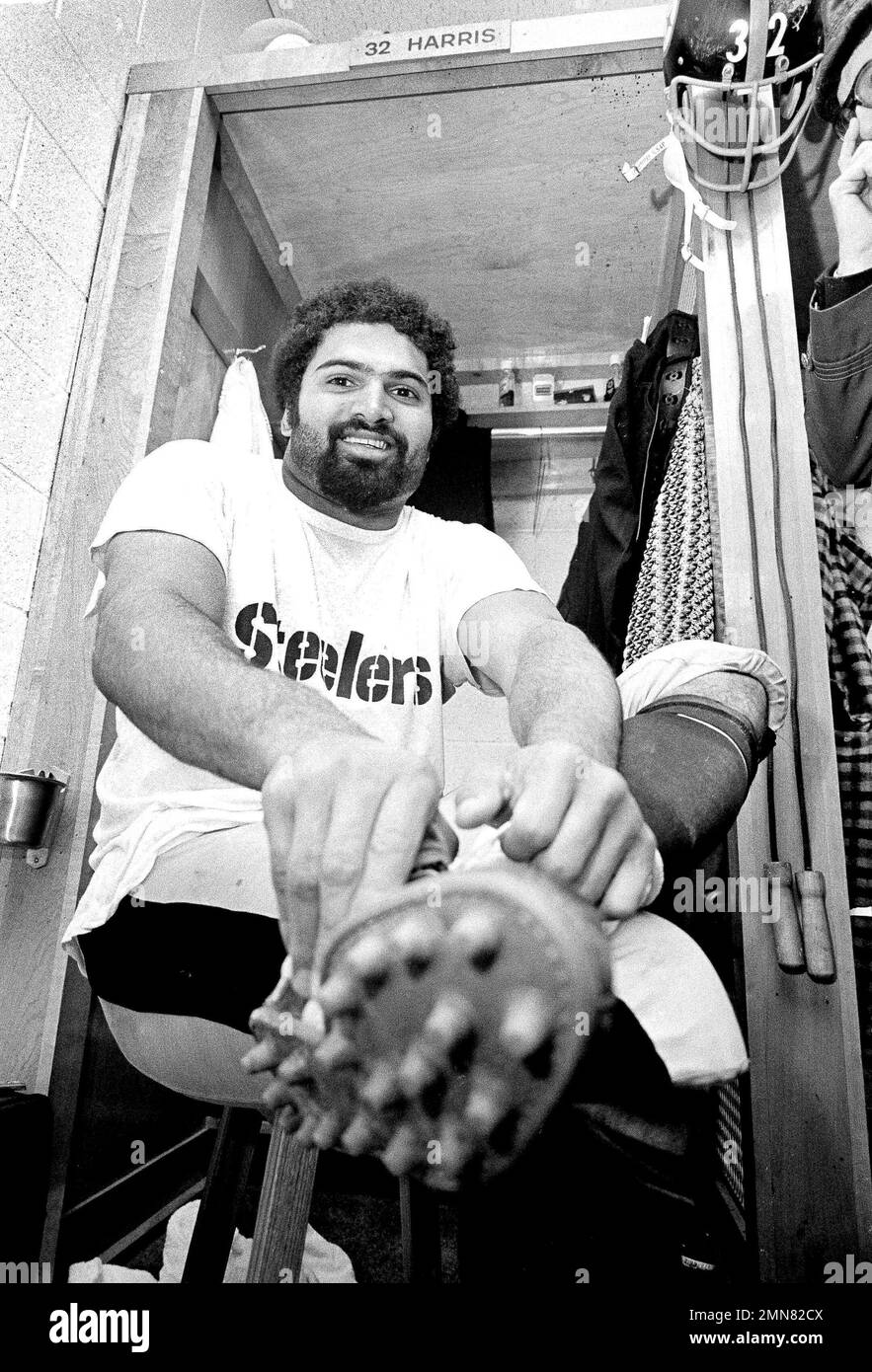 Steelers running back Franco Harris unties his shoes in the locker room ...