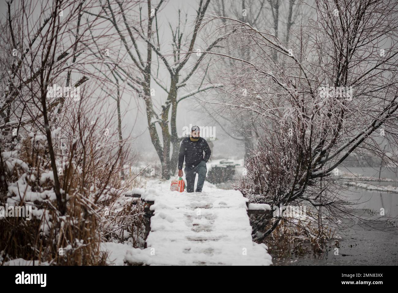 Srinagar, India. 30th Jan, 2023. A man walks along a snow covered ...