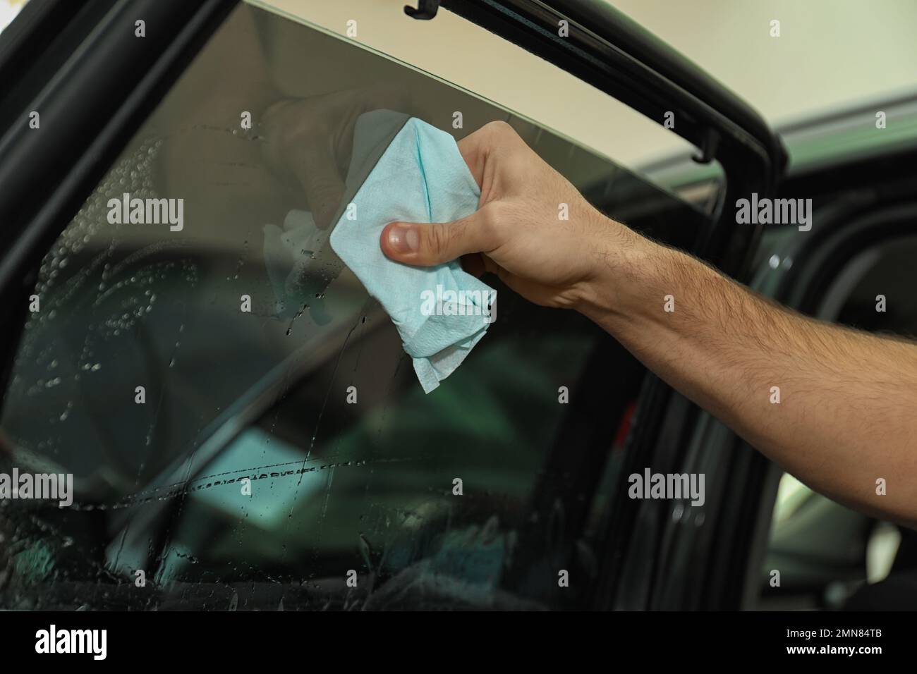 Worker washing tinted car window in workshop, closeup Stock Photo - Alamy