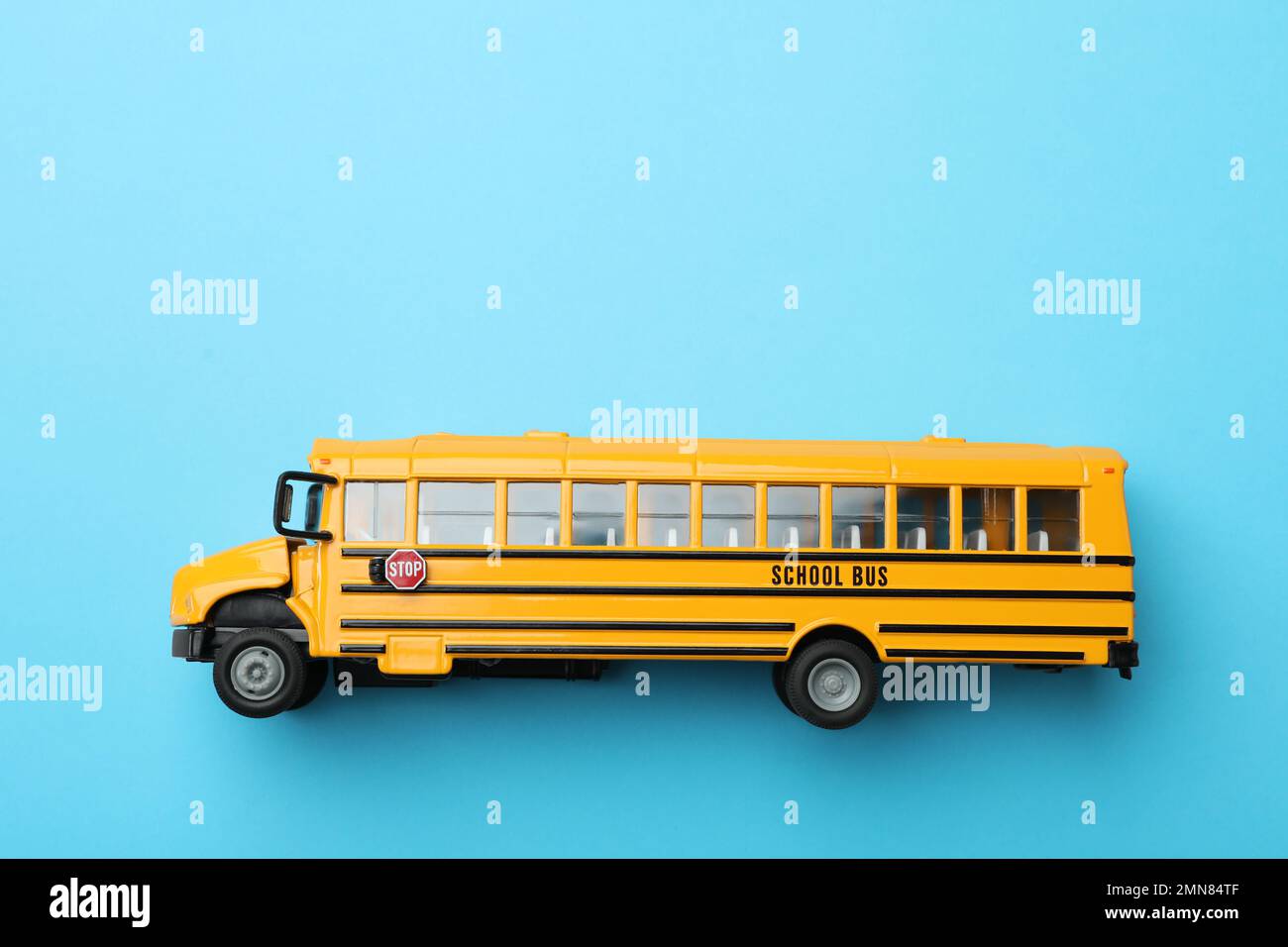 Yellow school bus on light blue background, top view with space for ...