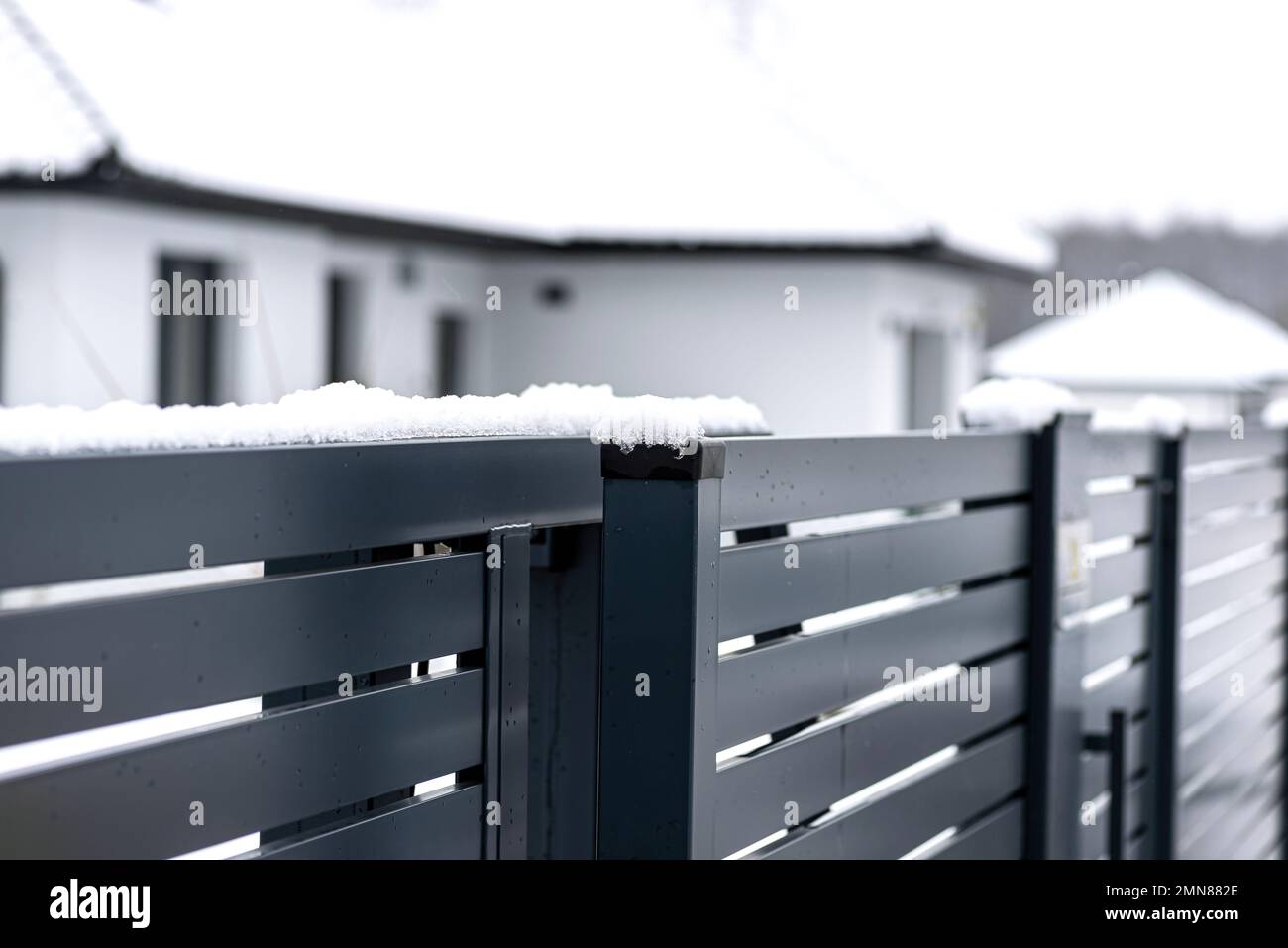 Modern anthracite panel fence with falling snow, visible sliding gate ...