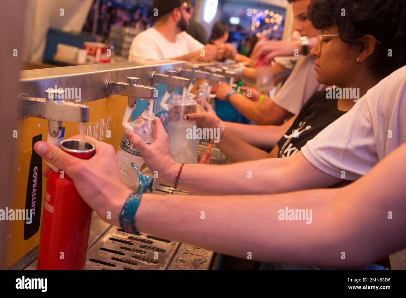 Concertgoers fill up free water from a refilling station at The ...