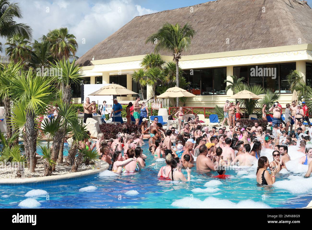 Guests having fun at a New Year's Eve foam party in a swimming pool in ...