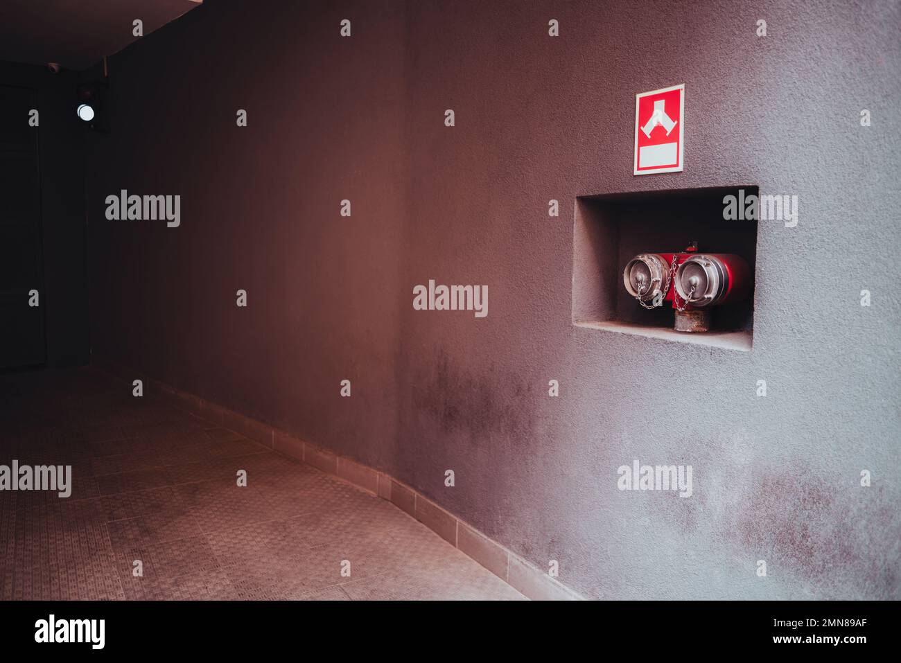 A wide-angle low-key shot of a closed fire fighting doubled hose ...