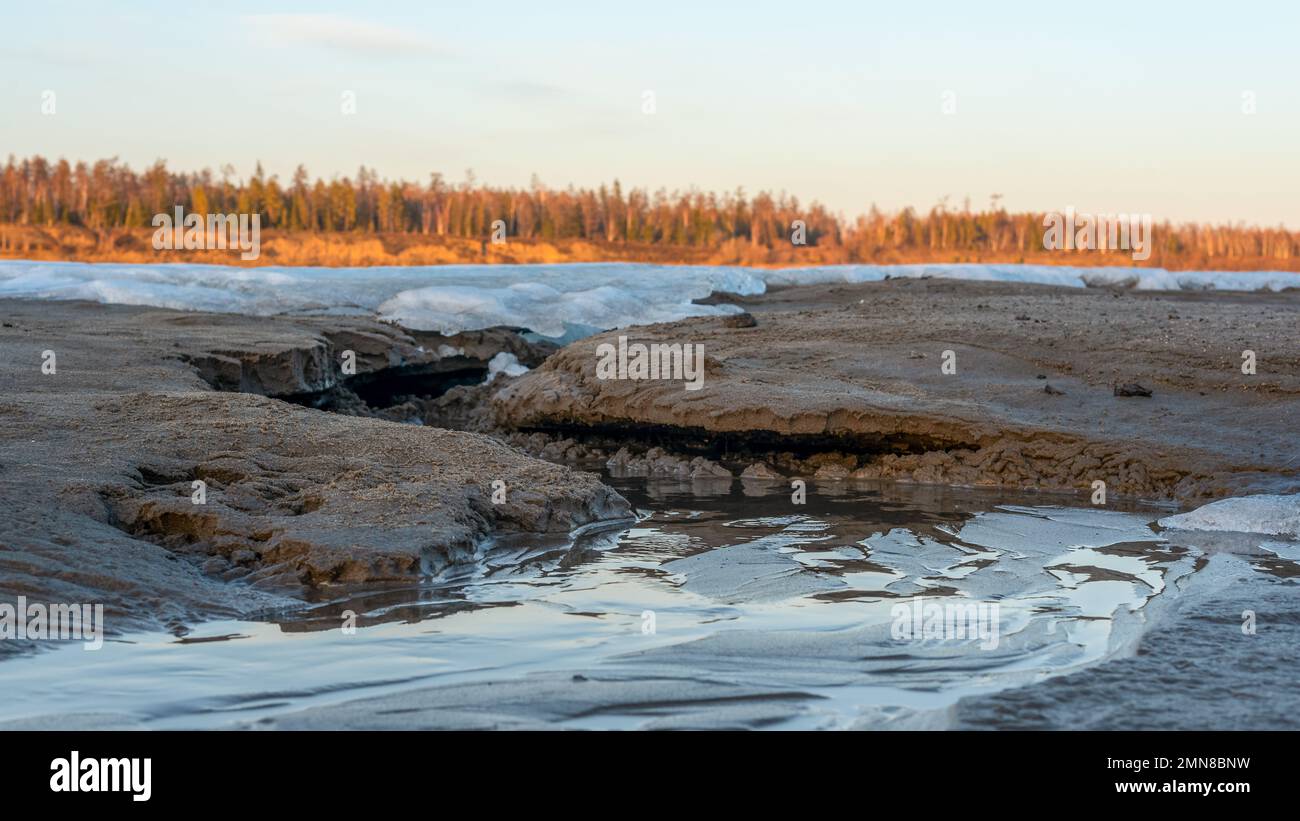Sand washed out by melting ice in spring against the backdrop of a ...