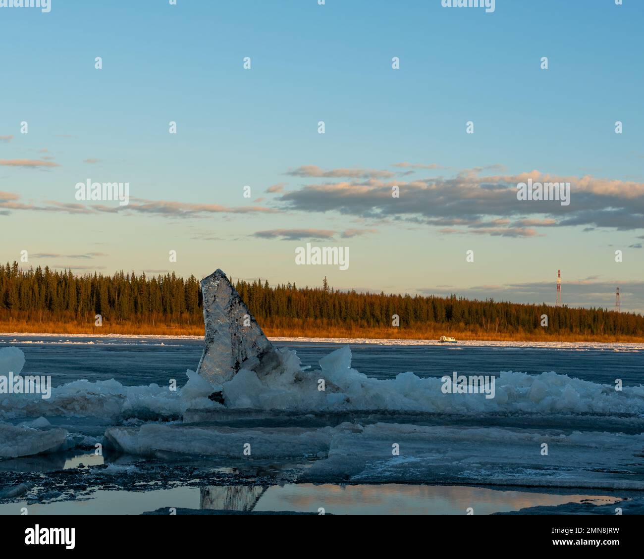 An ice floe in the form of a shark's fin sticks out of the surface of a ...