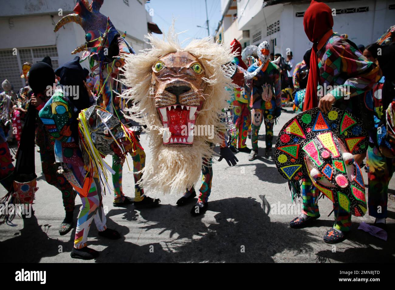 People dressed as a dancing devils with giant mask dance on a street ...