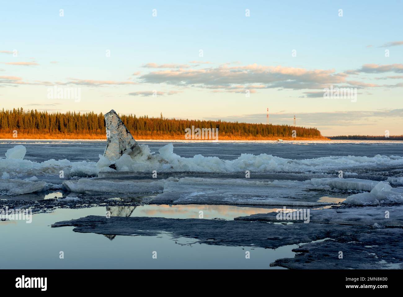 An ice floe in the form of a shark's fin with the reflection of clouds ...