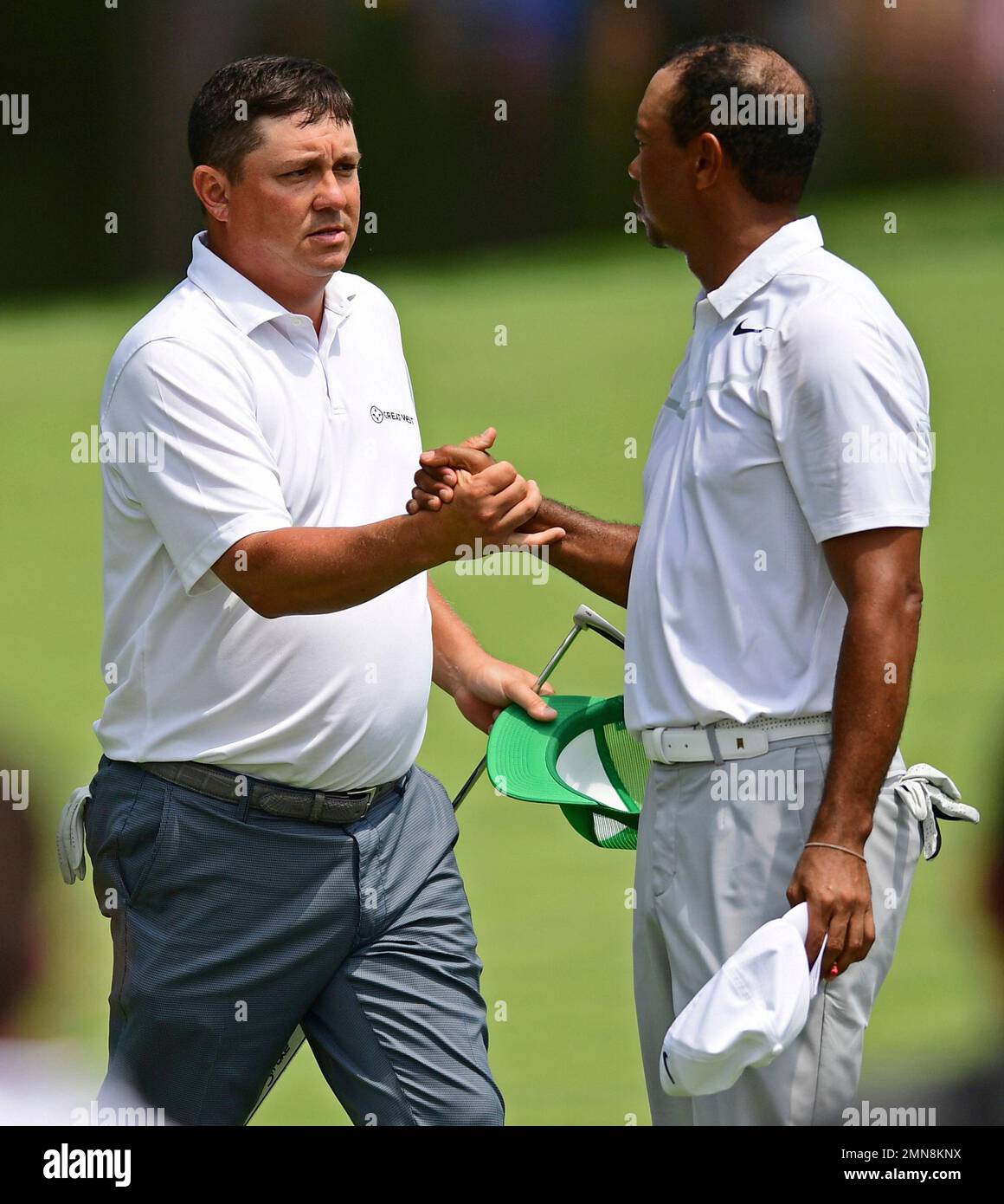 Jason Dufner, left, shakes hands with Tiger Woods on the ninth hole ...