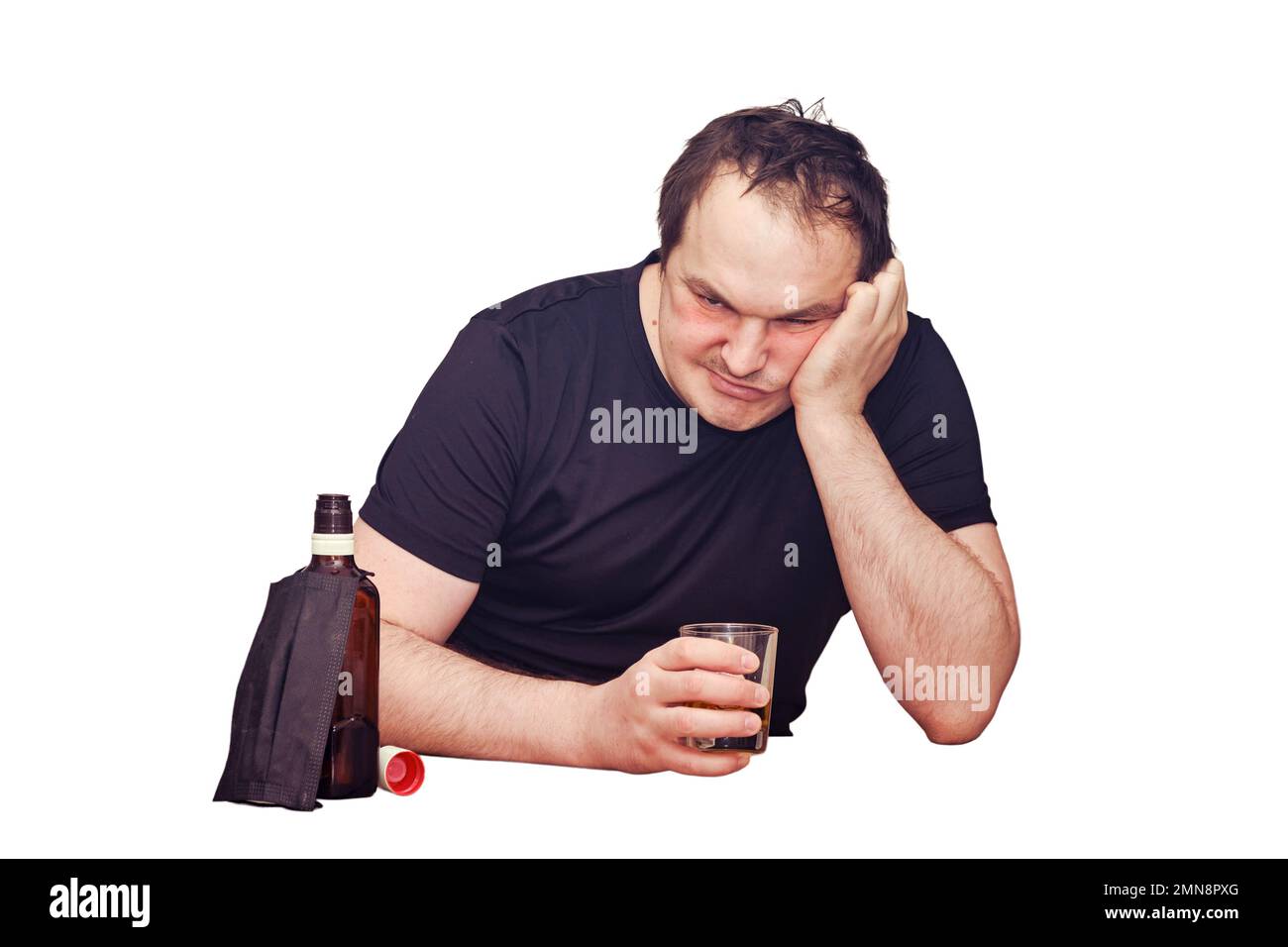 Angry man drinks alcohol sitting with a bottle of whiskey at the ...
