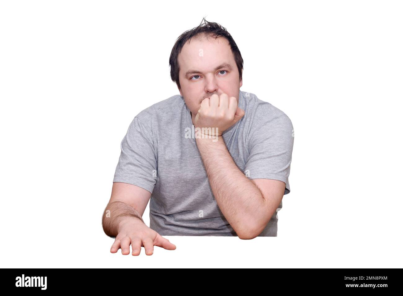 An adult man of 40 years old in casual clothes sits thoughtfully at the ...