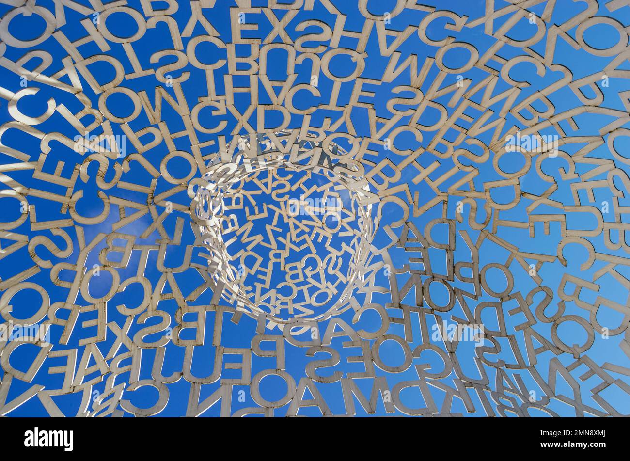 Swarm of white letters in the shape of a wall with blue sky Stock Photo ...