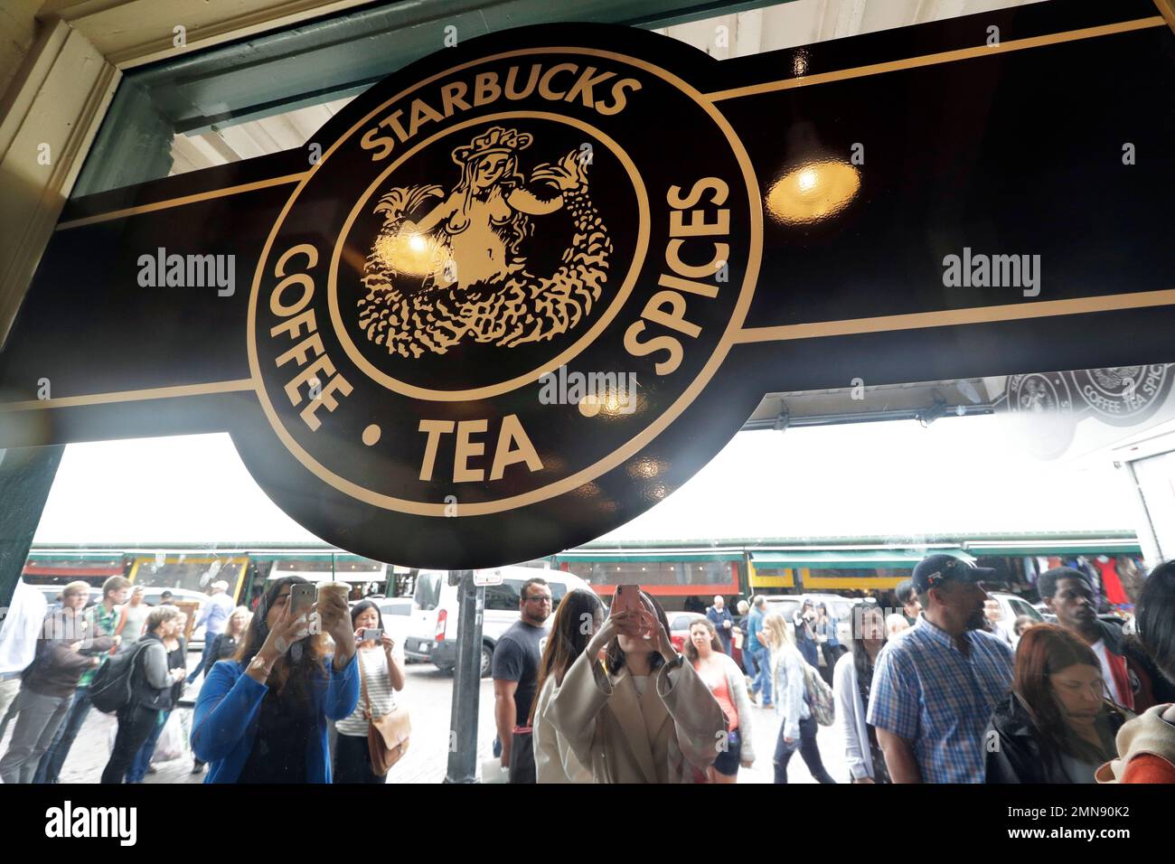 Visitors peer inside the Pike Place Market Starbucks, commonly referred ...