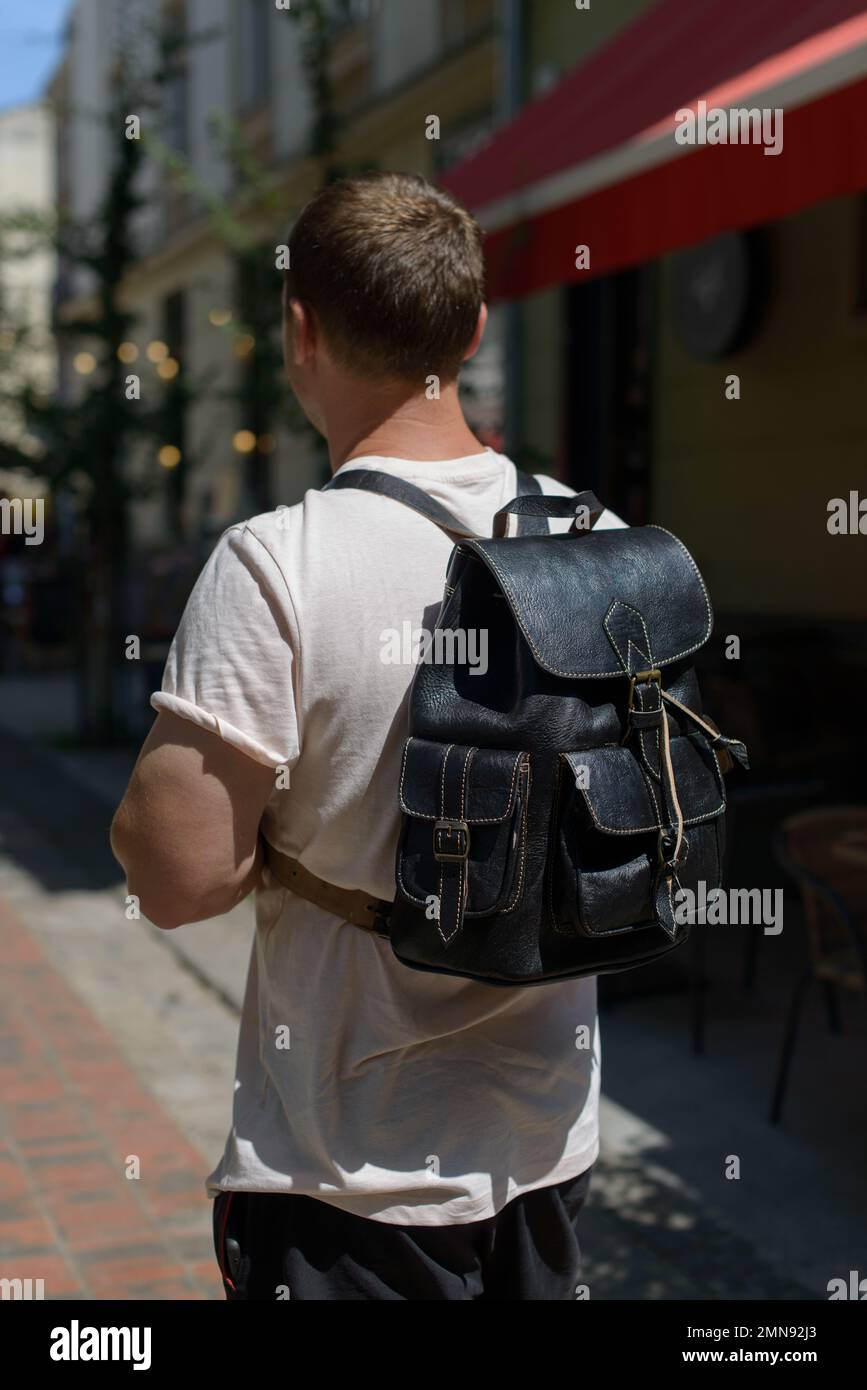 Part photo of a man with a black leather backpack with antique and ...