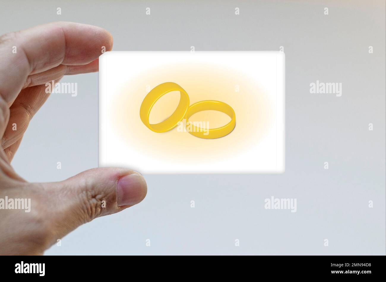 Hand holding card decorated with golden rings Stock Photo - Alamy