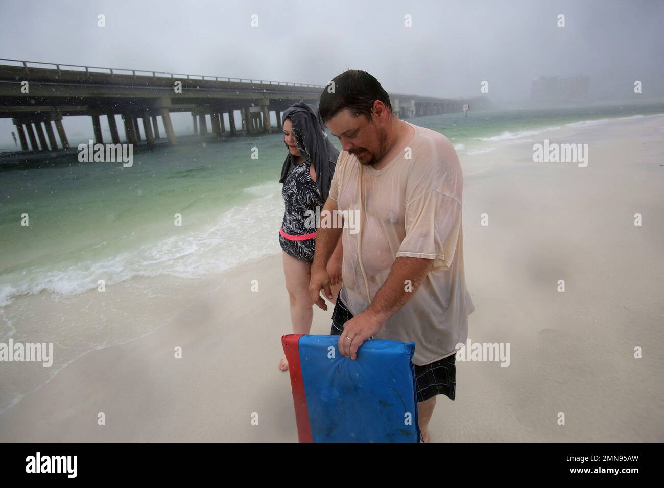 Emily Muller, left, and her father Bob walk through the rain as ...