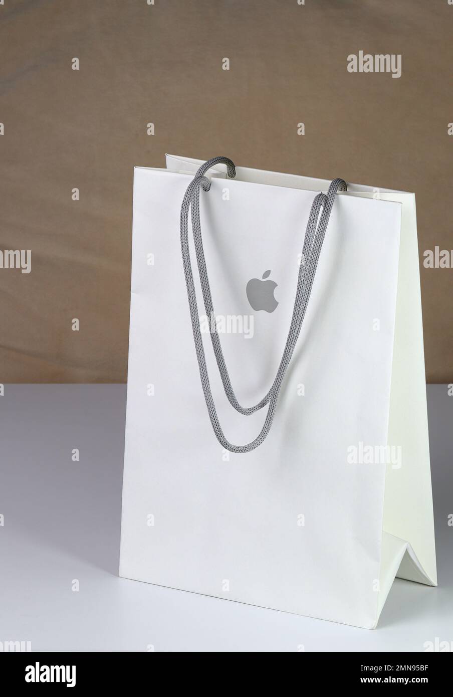 White paper shopping bag, present bag with Apple brand logo standing on ...
