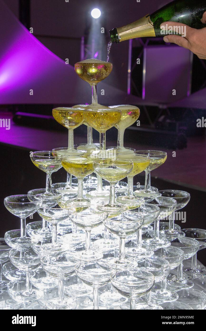 groom makes a champagne cascade show pyramid of glasses in wedding party Stock Photo - Alamy