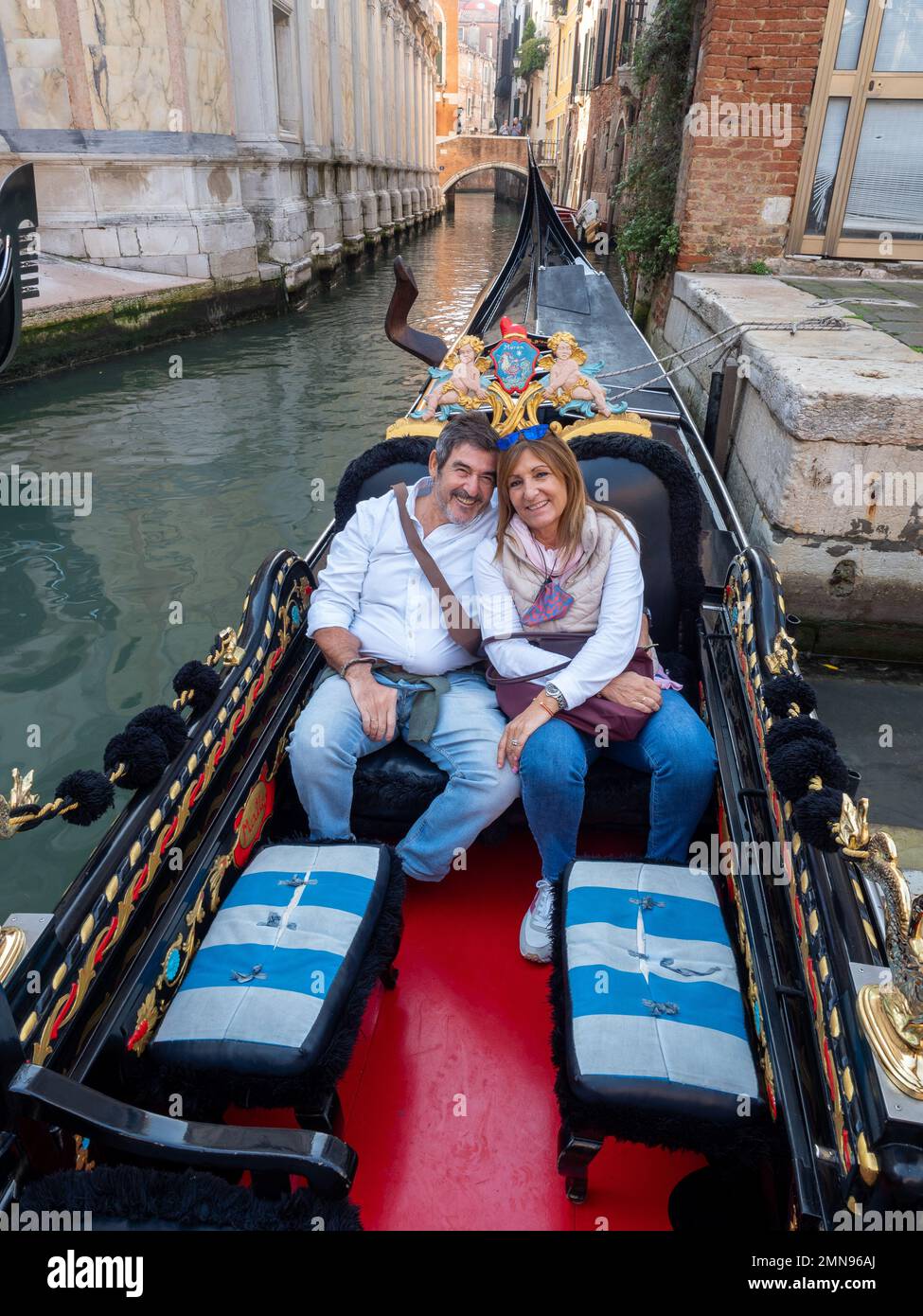 Couple Smiling While Enjoying A Ride In A Gondola In Venice Italy