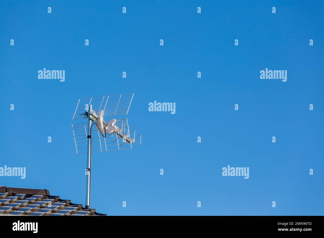 A domestic television aerial on a roof in a clear blue sky, Scotland ...