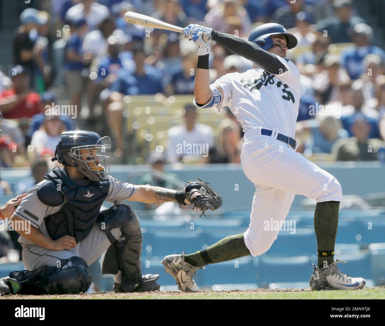 Los Angeles Dodgers' Cody Bellinger, right, follows through on his two ...